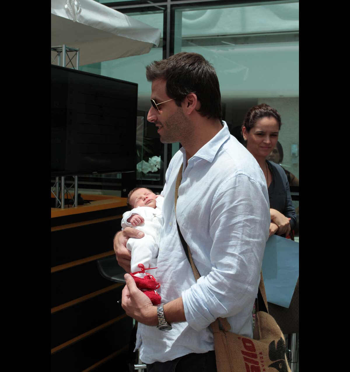 Foto: Henri Castelli segura a filha nos braços na saída do hospital, em ...